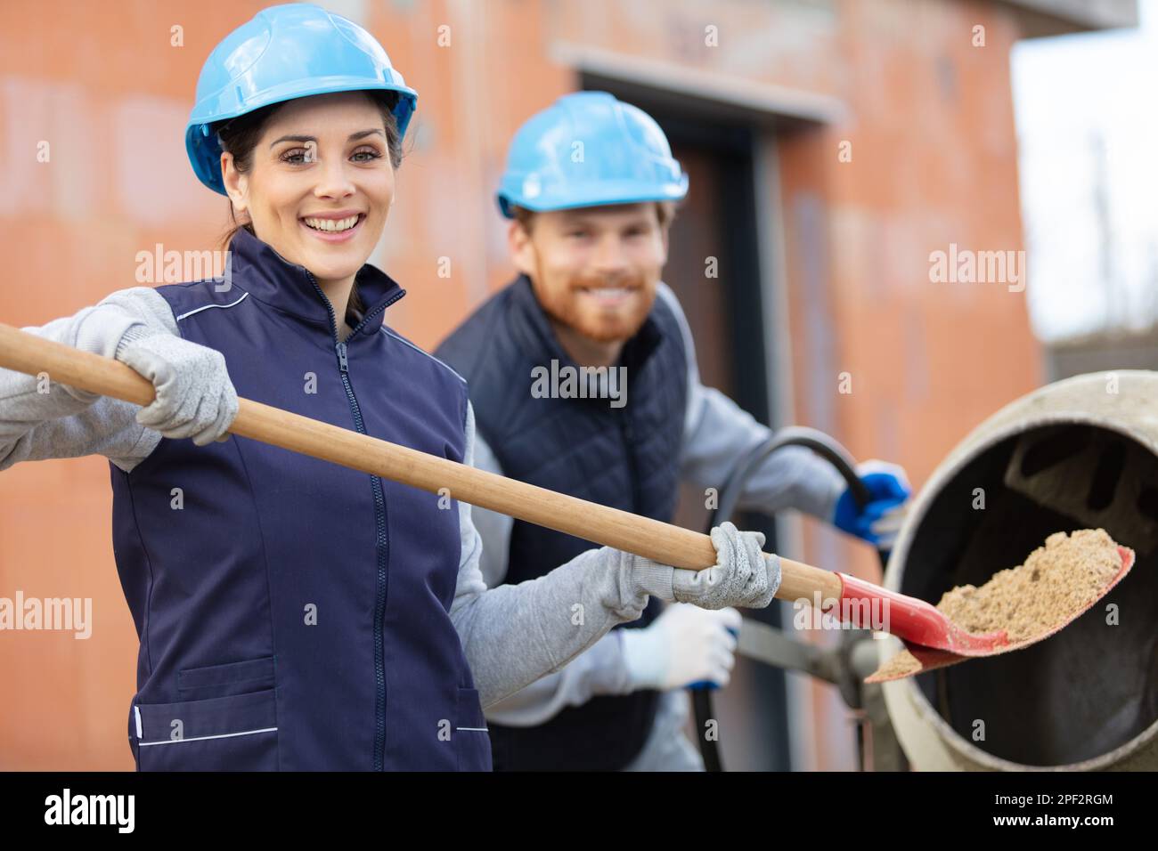 male female shoveling sand to make cement at construction site Stock ...