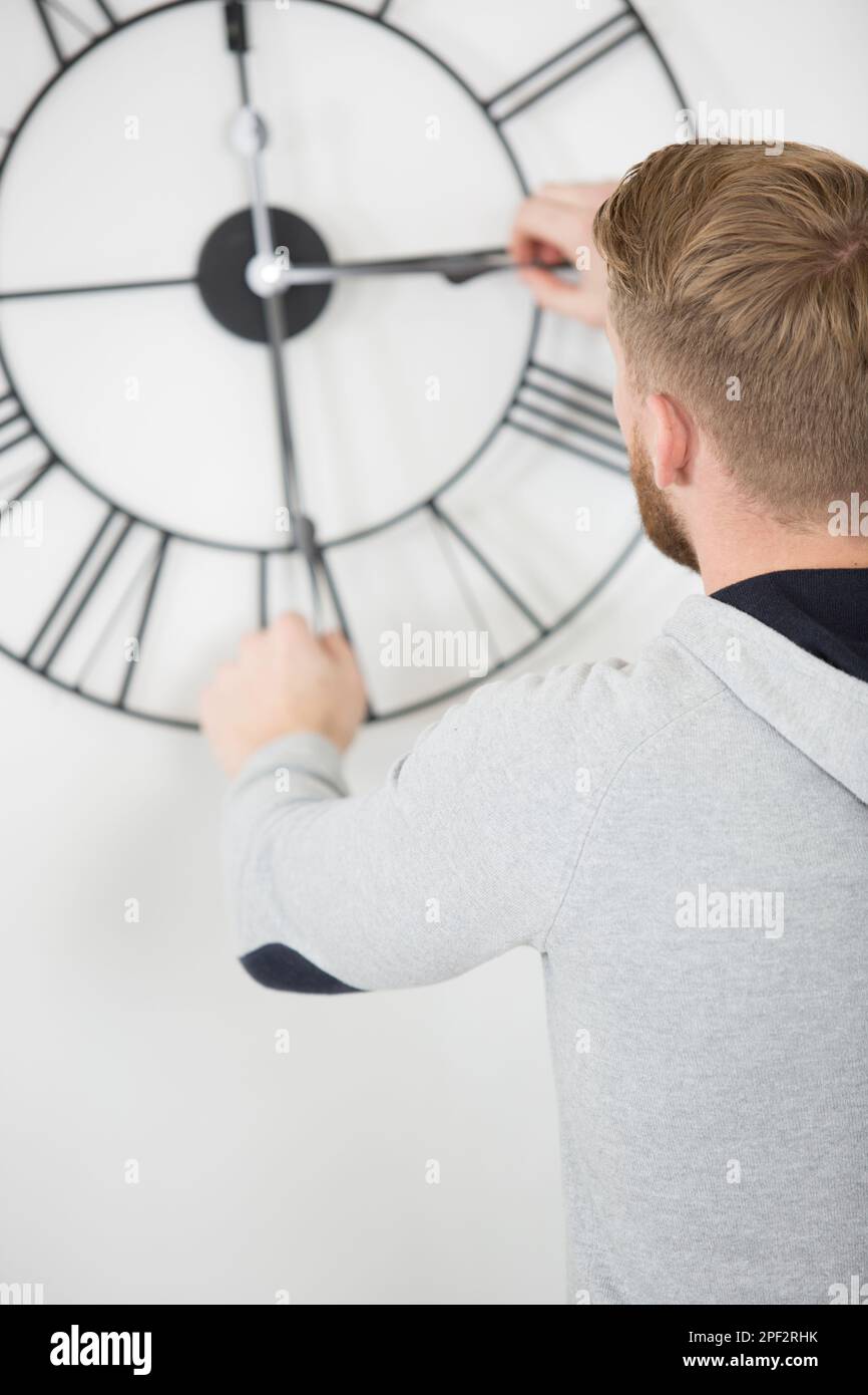 rear view of man setting the hands of a clock Stock Photo - Alamy