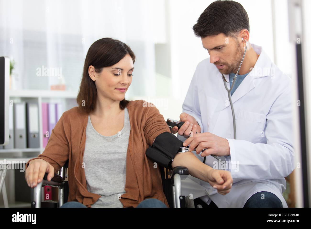 man doctor of checking the arm of female patient Stock Photo - Alamy