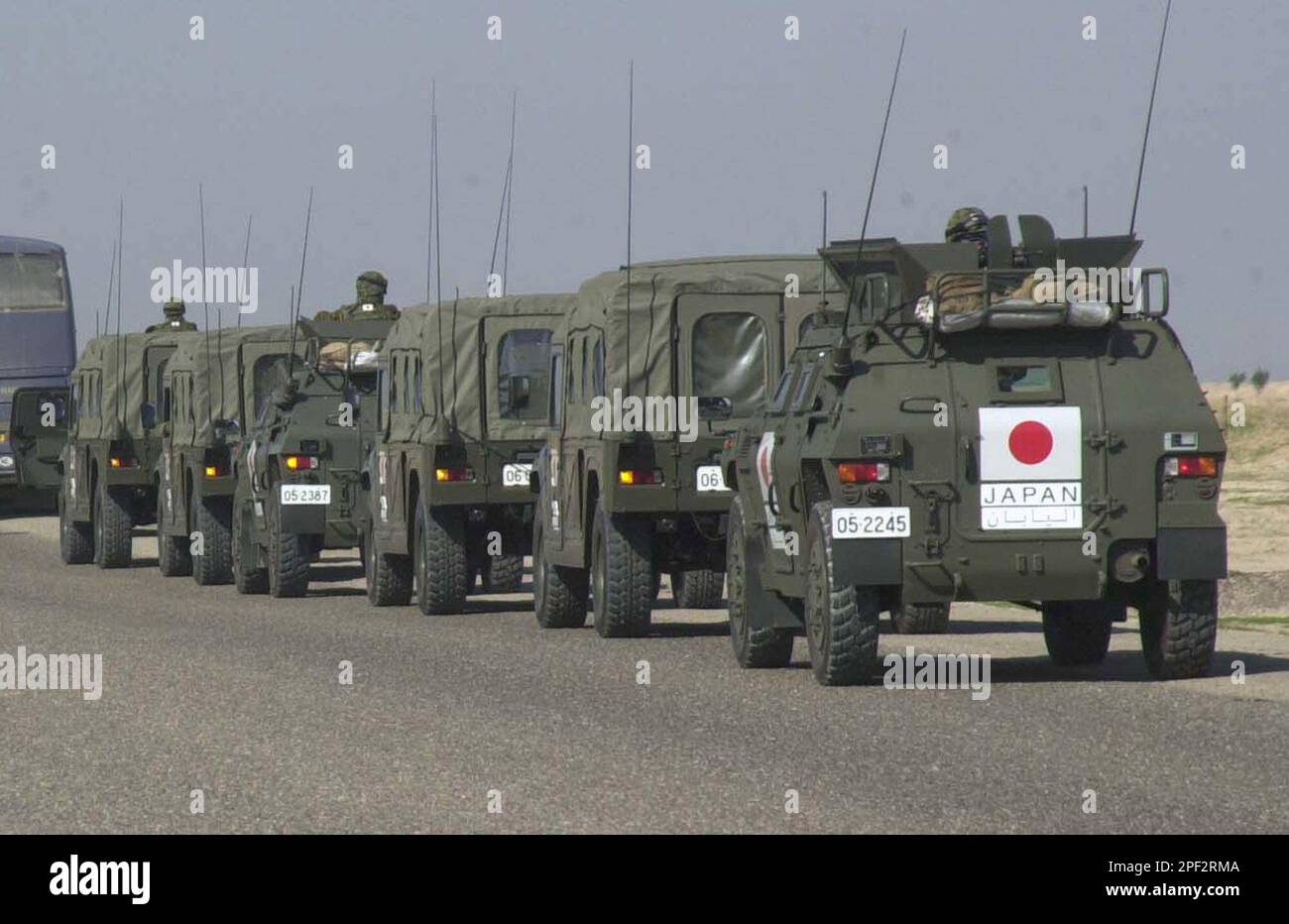 A convoy of Japanese troops crosses the border from Kuwait into ...
