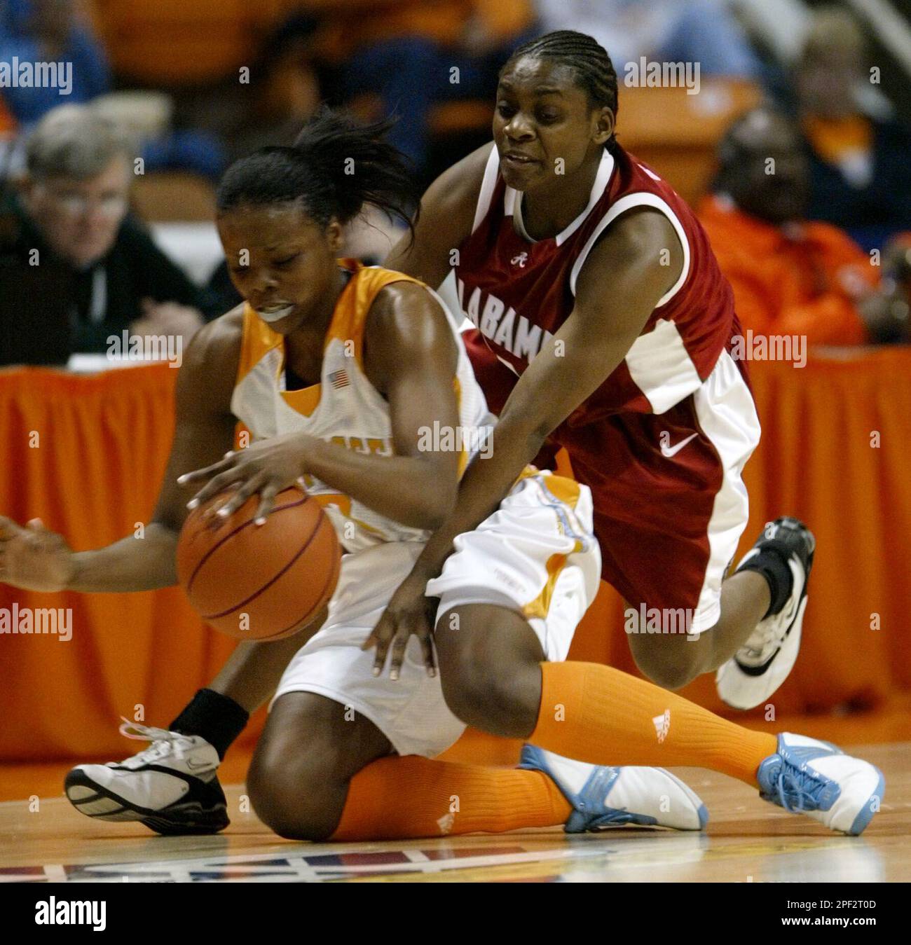 Tennessee's Tasha Butts, front, goes to the floor as she's fouled by ...
