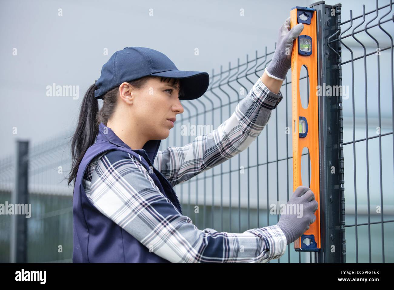 woman building fence - checking with spirit level Stock Photo - Alamy