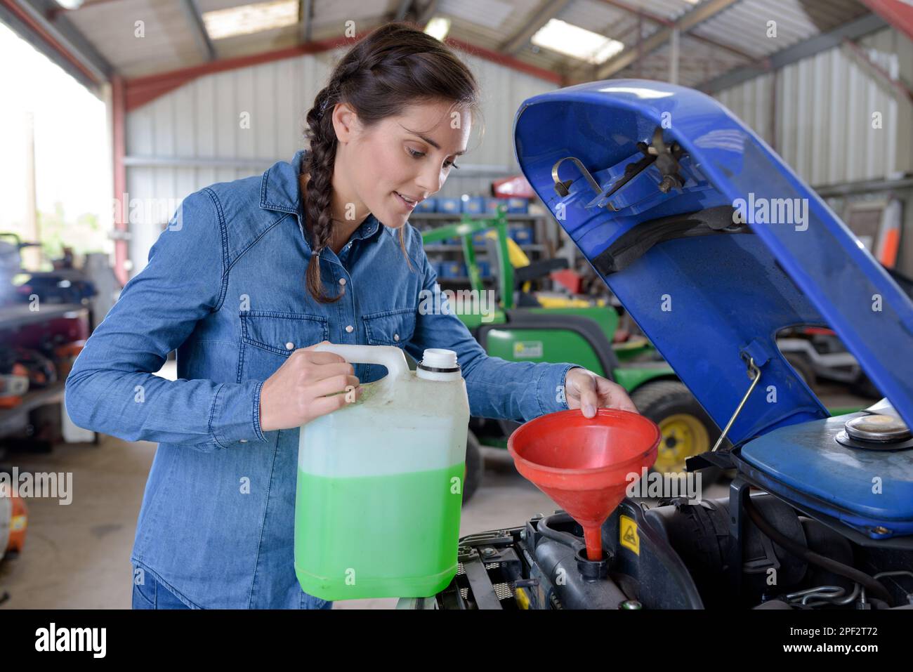 woman adding coolant water to a vehicule engine Stock Photo - Alamy