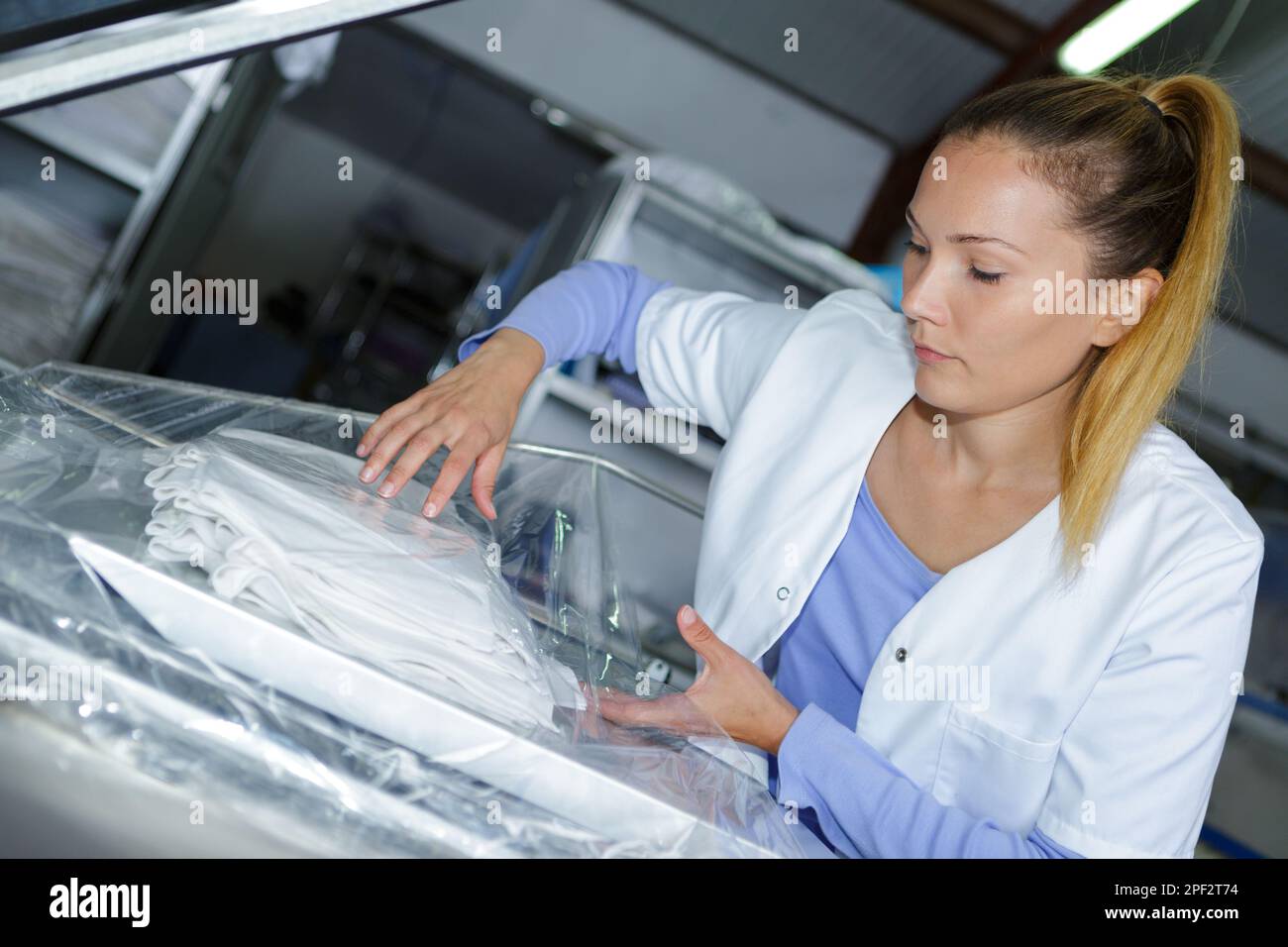 woman shrink wrapping clean laundry in plastic Stock Photo - Alamy
