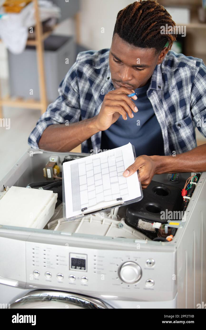 male engineer making quote to repair washing machine Stock Photo - Alamy
