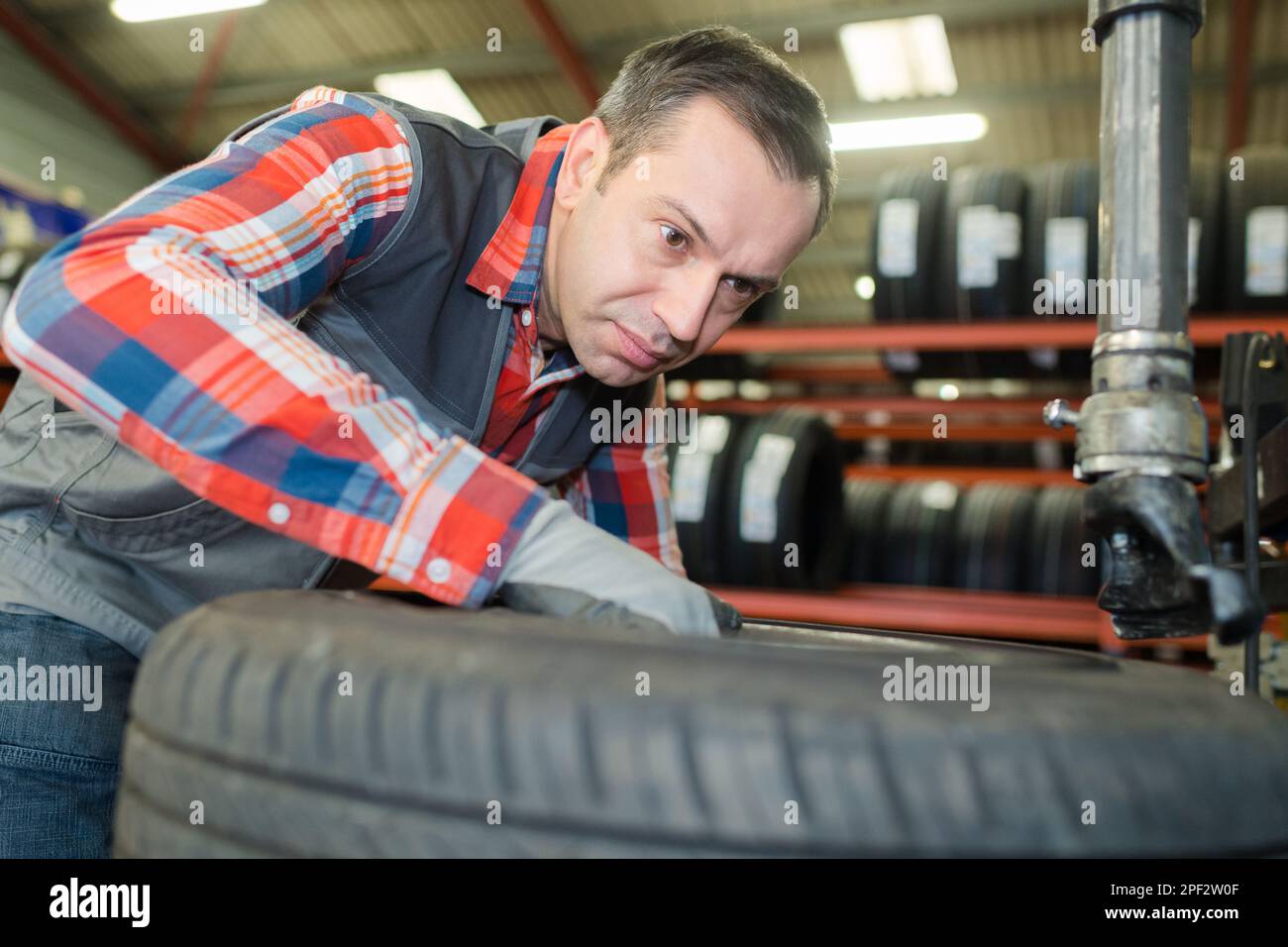 professional car mechanic balancing car wheel Stock Photo - Alamy