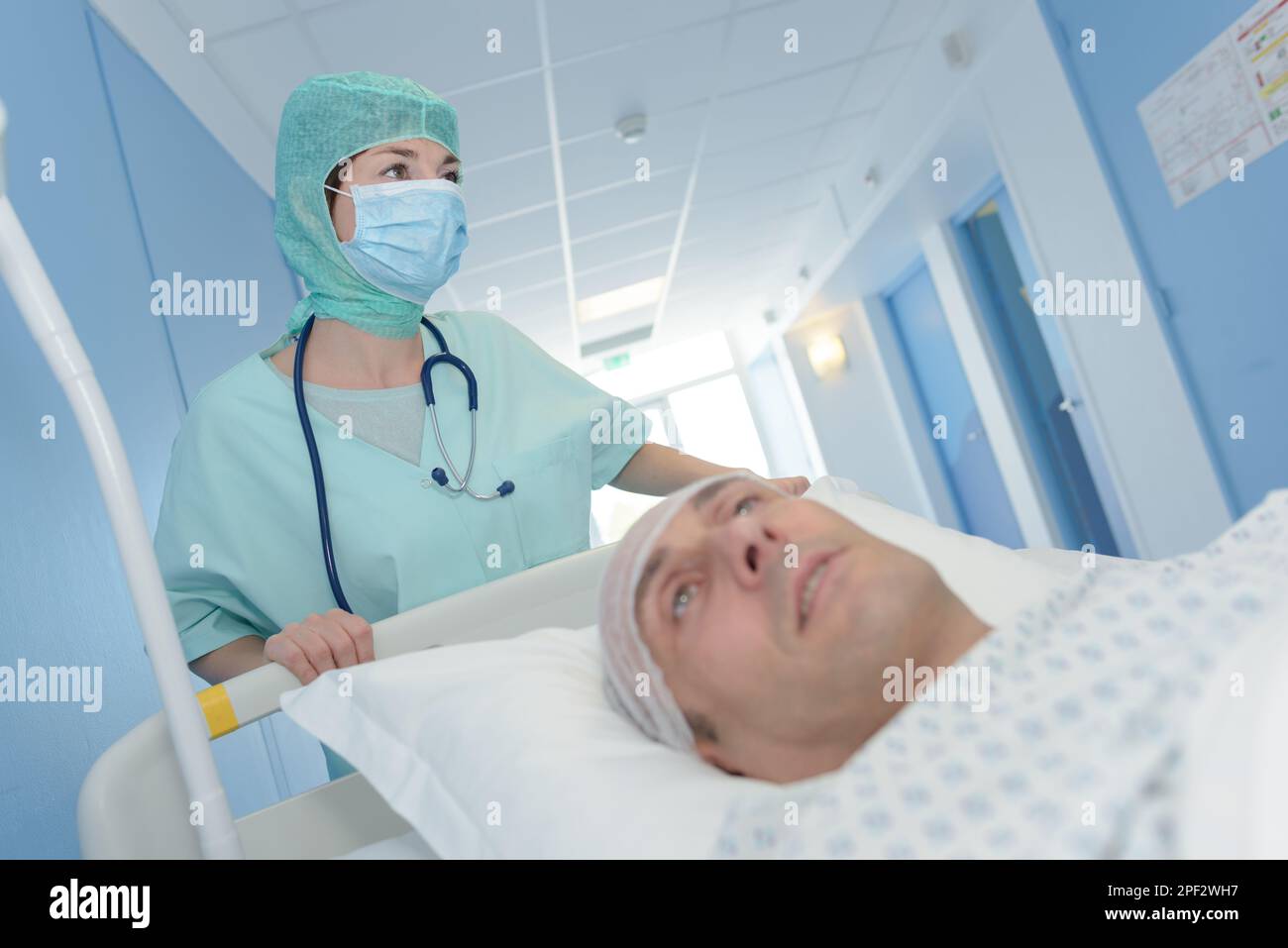 doctor in medical uniform transporting a patient to surgery Stock Photo ...
