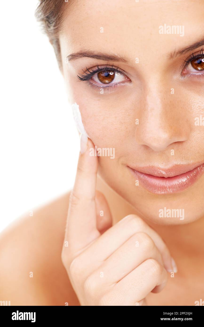 Taking care of her beauty. Studio shot of a beautiful young woman ...