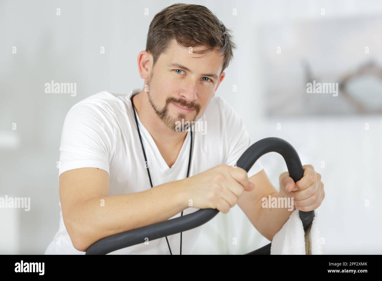 sporty man riding stationary bicycles in gym Stock Photo - Alamy