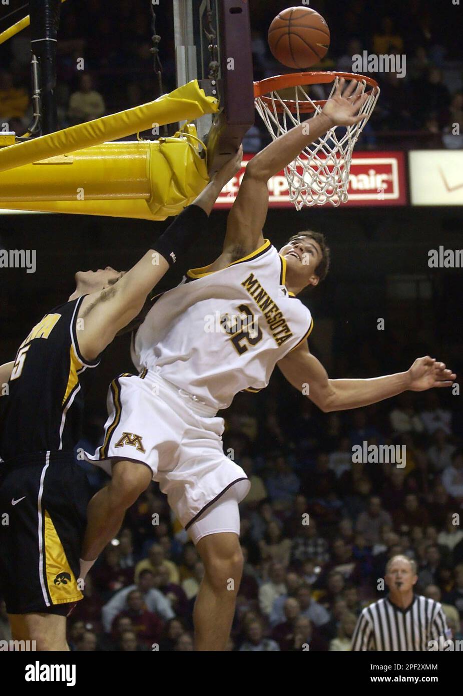Iowa center Jared Reiner, left, makes a layup past Minnesota forward ...