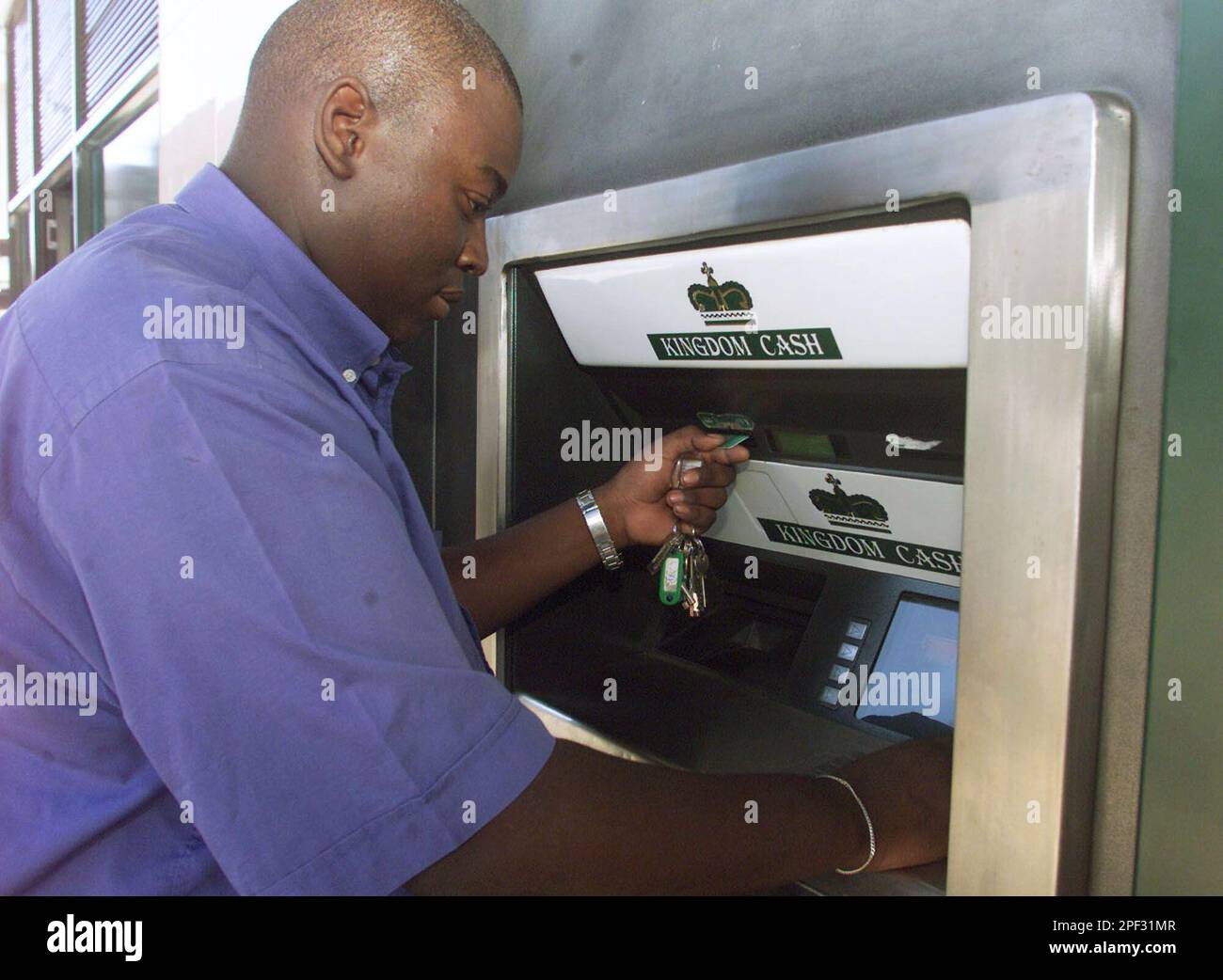 Tendai Chari, attempts to withdraw money from a cash machine at a local ...