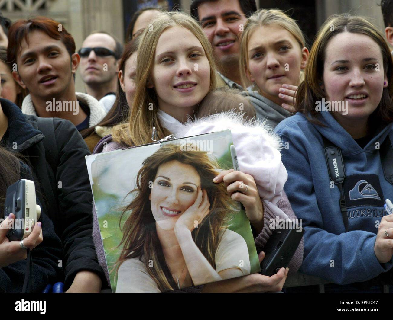 Diana Luts-Leaton, center, holds her baby Hellik and a photo of singer ...