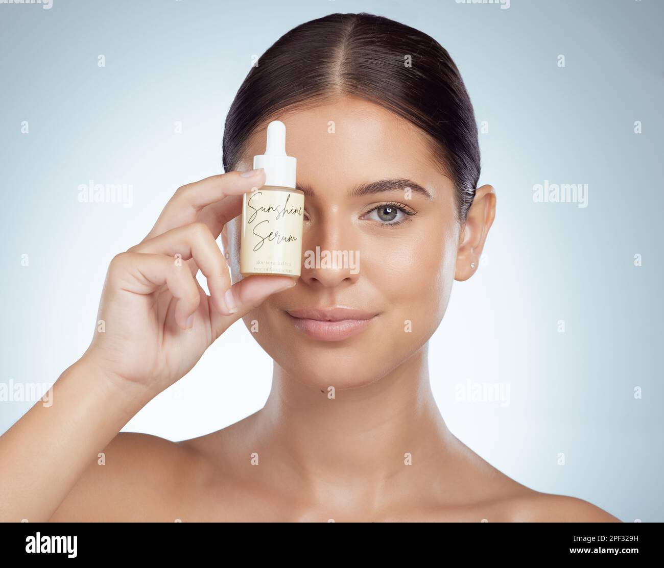 Closeup portrait beautiful woman holding face serum over eye while ...