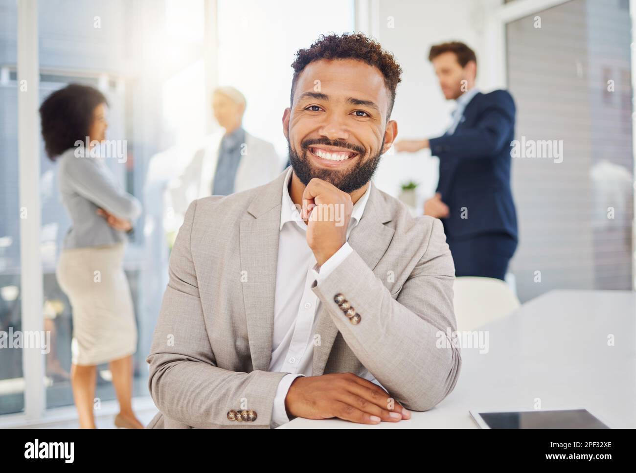 Portrait of a confident young mixed race businessman smiling with hand ...