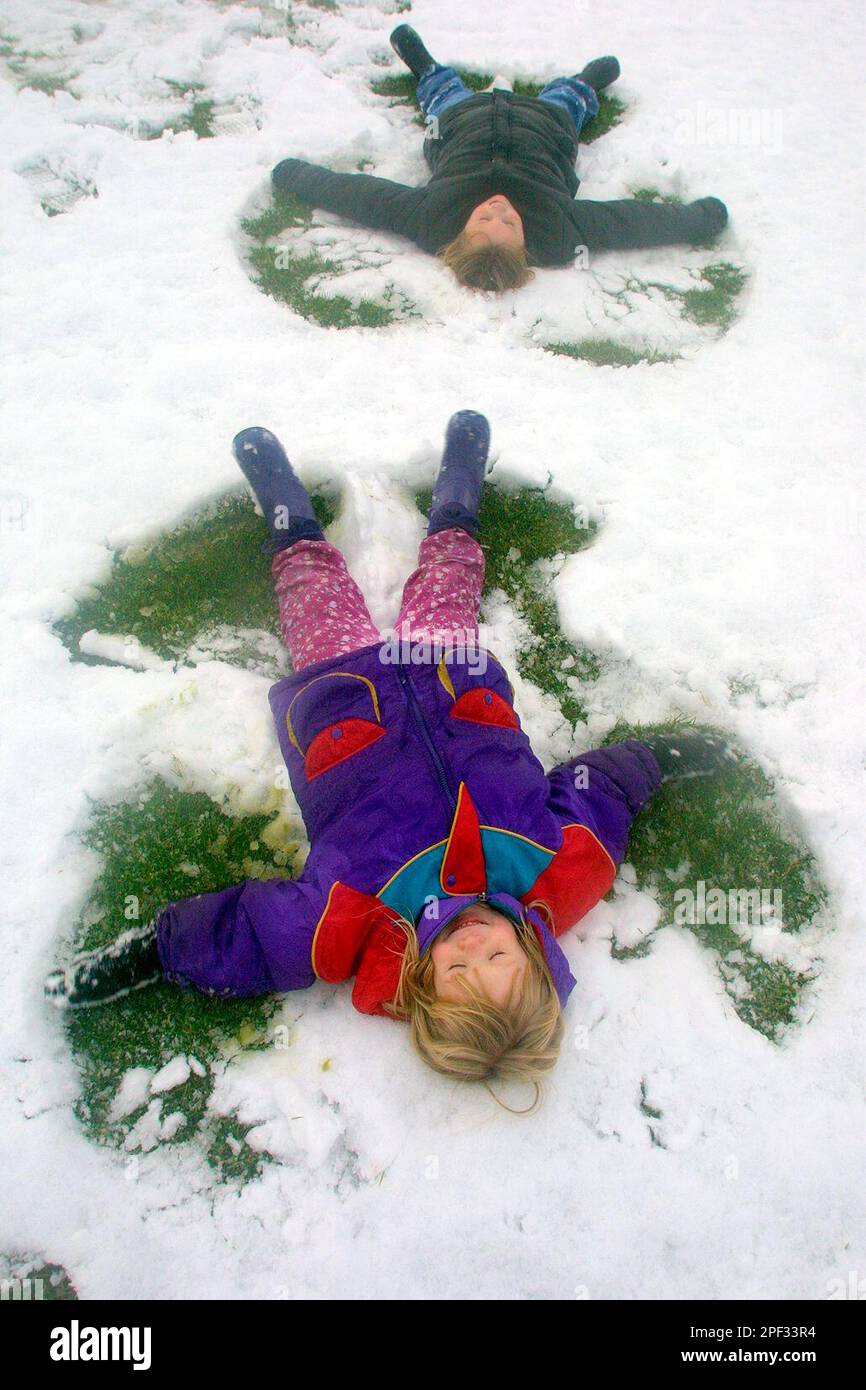 Desiree Coleman,5, bottom, and her sister Katlynn,7, make snow angels ...