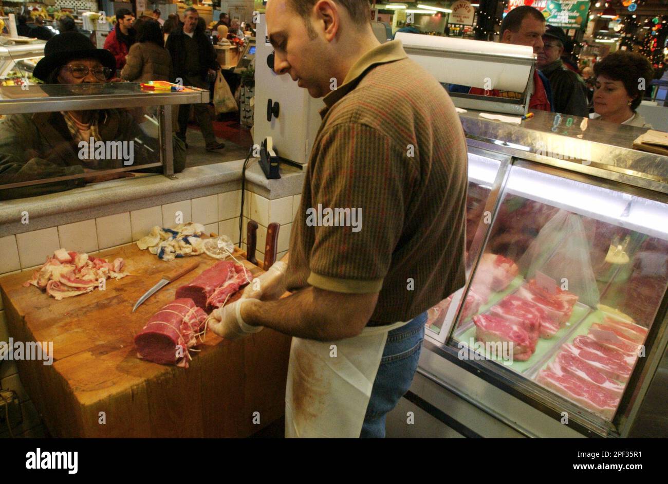 Nicholas Ochs prepares beef for a customer at Harry G. Ochs Prime Meats ...