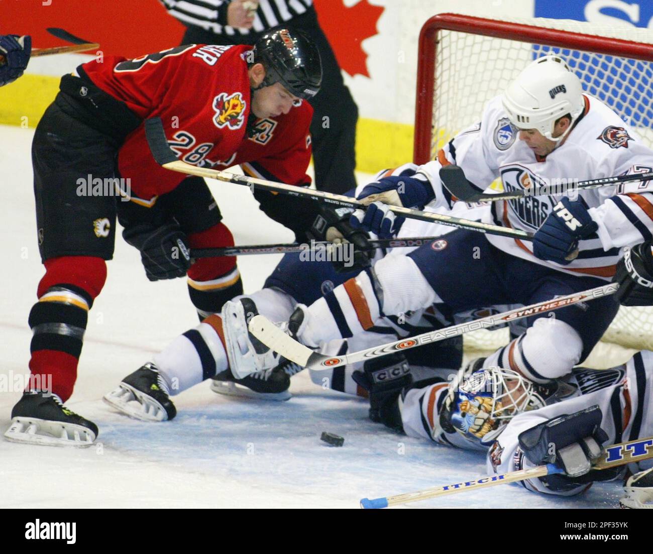 Edmonton Oilers' Adam Oates, right, lands on Oilers goalie Tommy Salo ...
