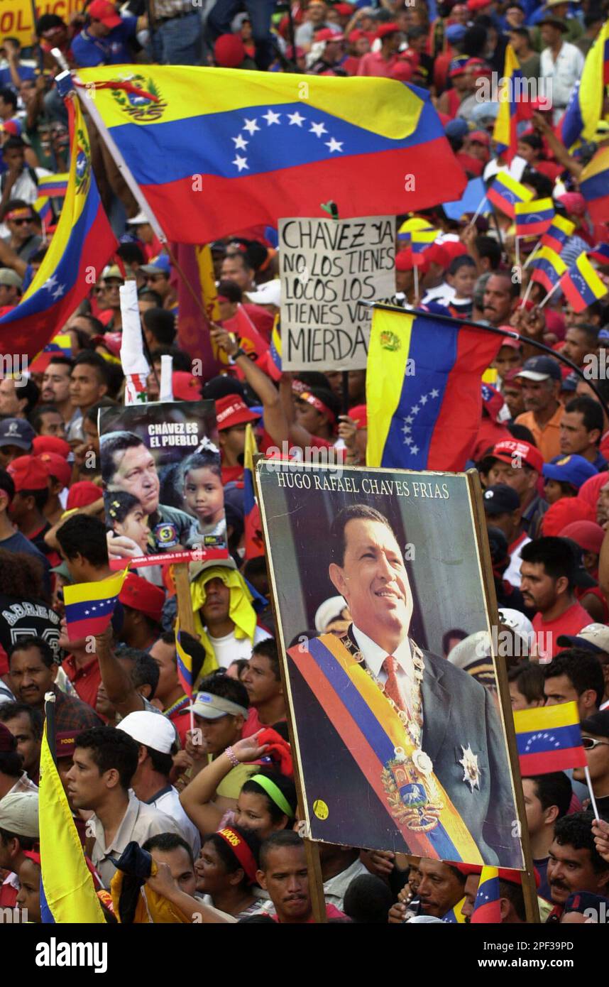 Supporters of Venezuela's President Hugo Chavez hold posters of him at ...