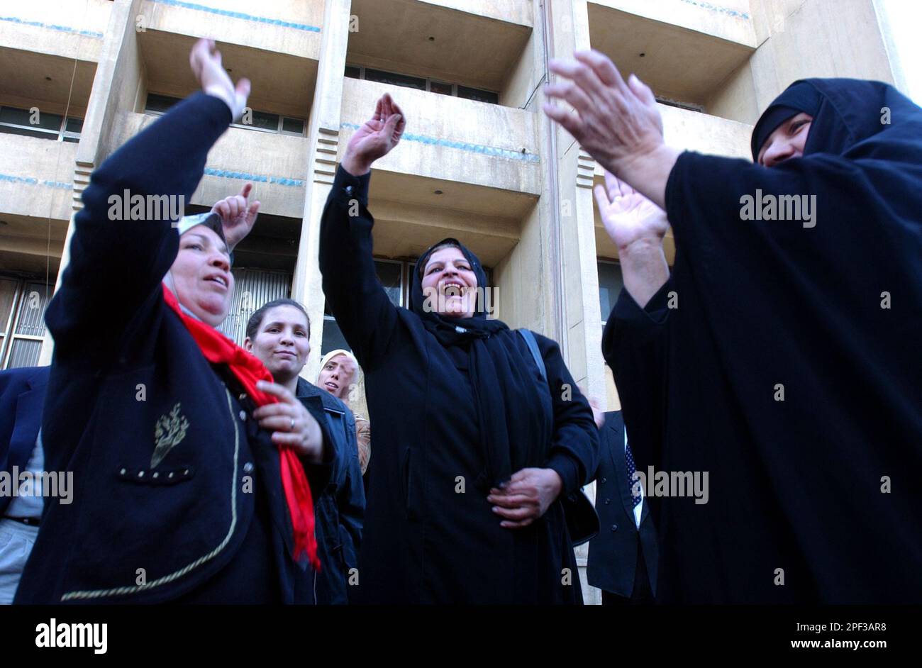 Iraqi women celebrate the capture of former Iraqi leader Saddam Hussein ...