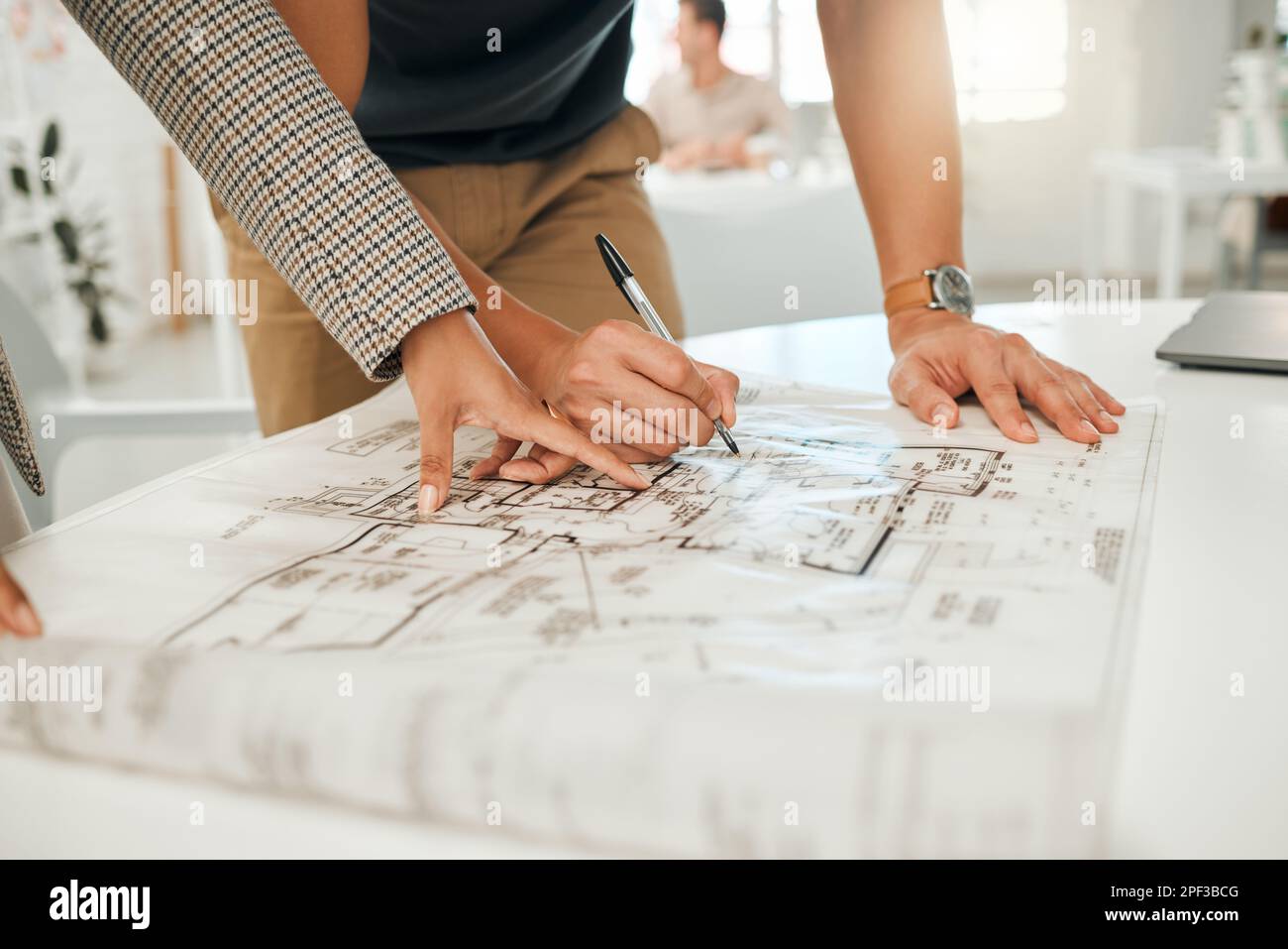 Businesspeople working on building plan together. Hands of colleagues ...