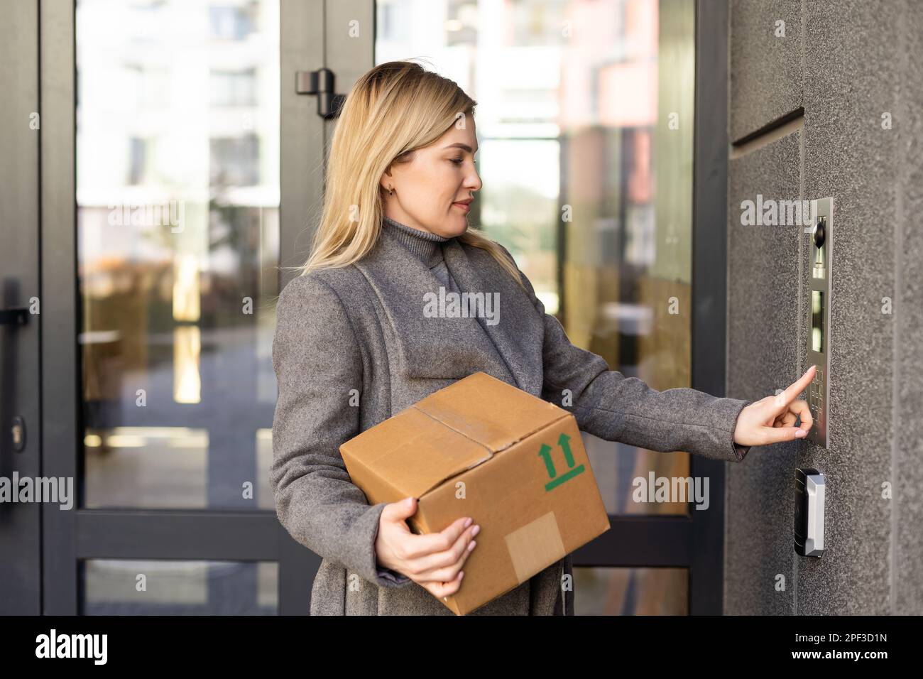 woman using intercom at building entrance Stock Photo - Alamy