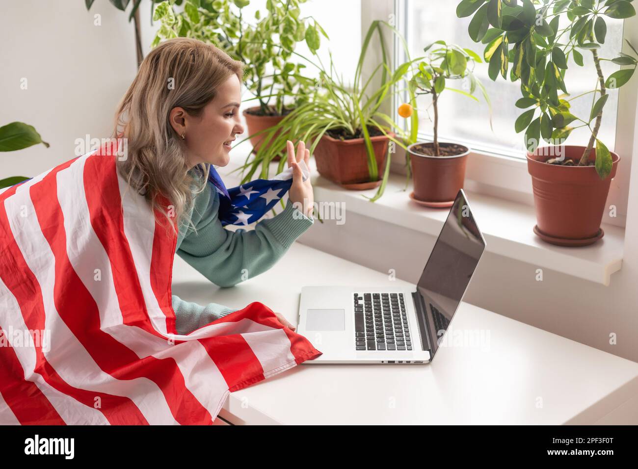 Happy woman employee sitting wrapped in USA flag, shouting for joy in ...