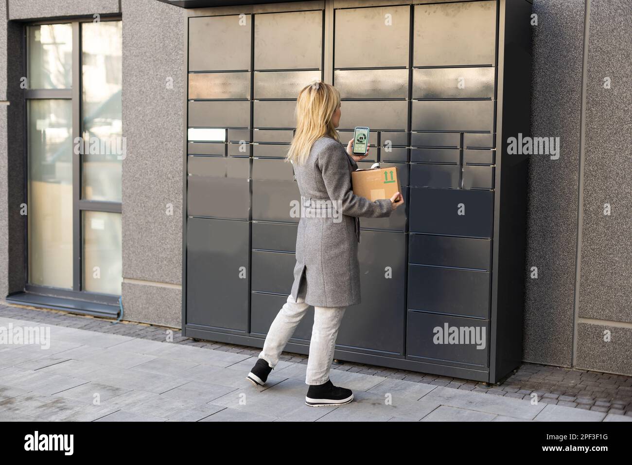 Beautiful woman picking up a package from a smart electronic steel ...