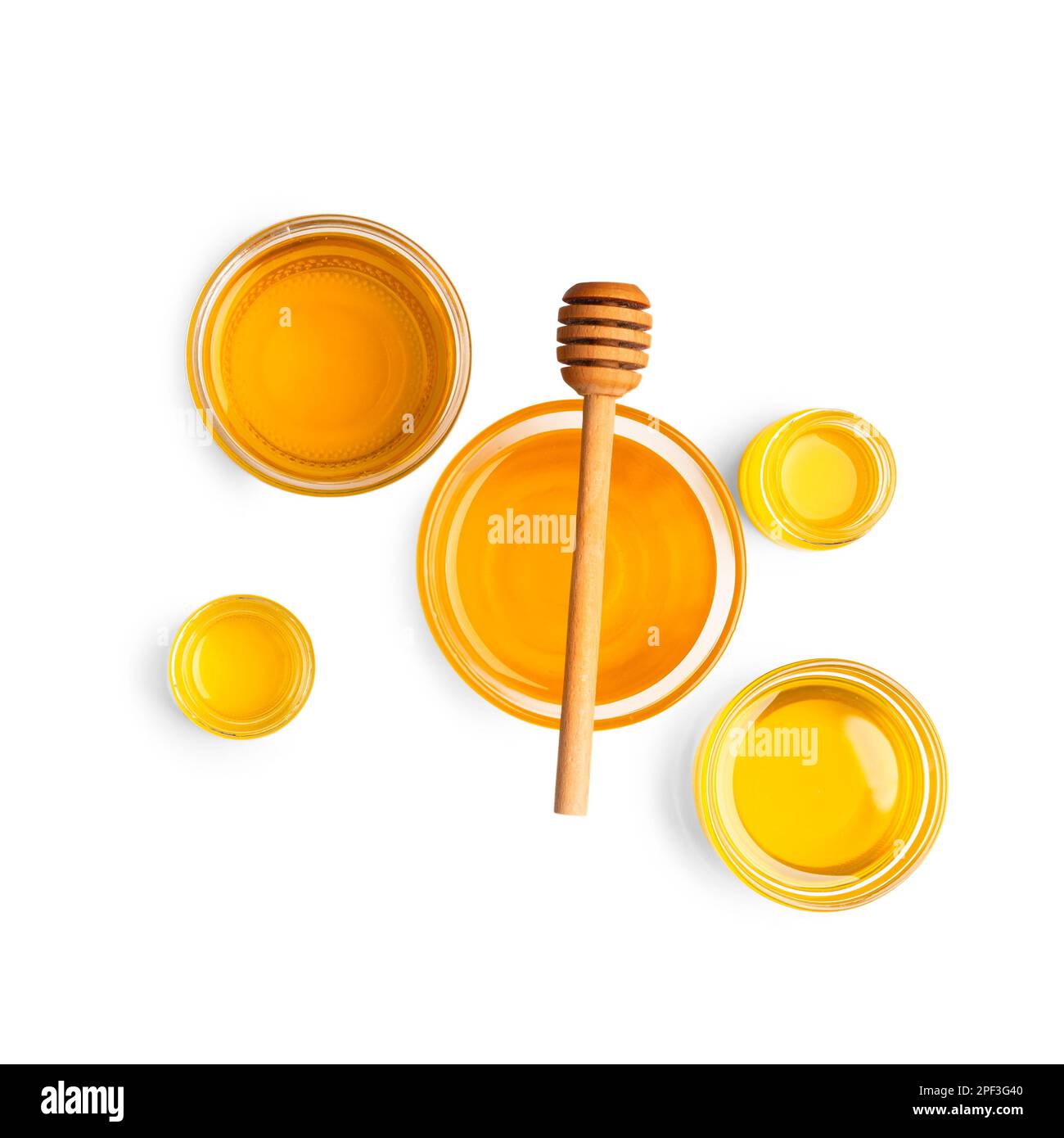 Creative composition of honey in glass bowls of different sizes and a ...