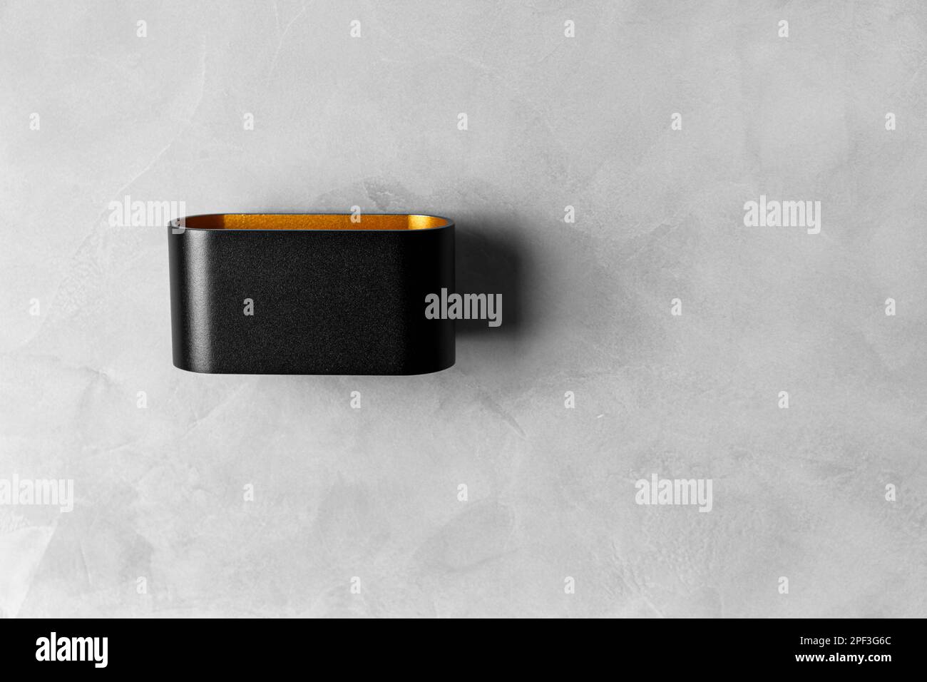 Modern black wall lamp on a gray texture wall with a place for the text ...