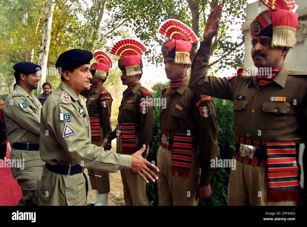 Pakistani army officers, left, extend their hands for a handshake as an ...