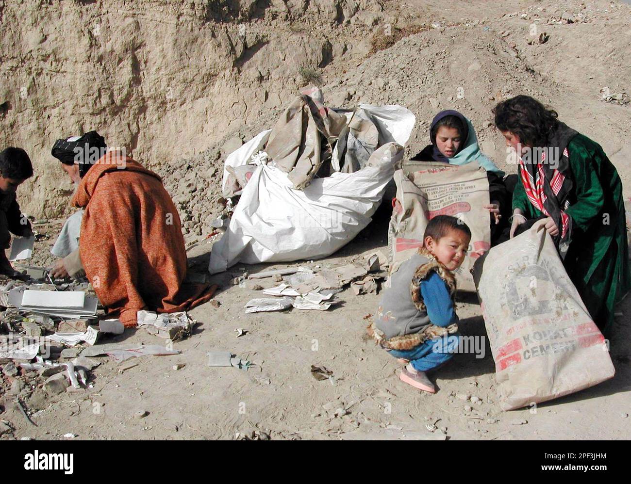 An Afghan man with his children gathers wastepaper on the street ...