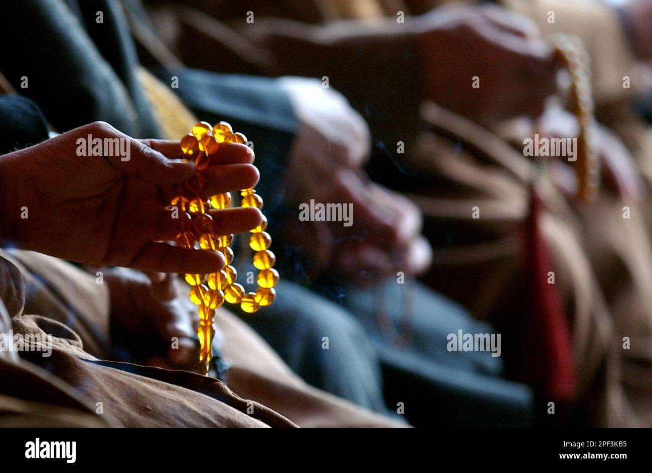 Iraqi men hold twirl their prayer beads during a meal celebrating a ...