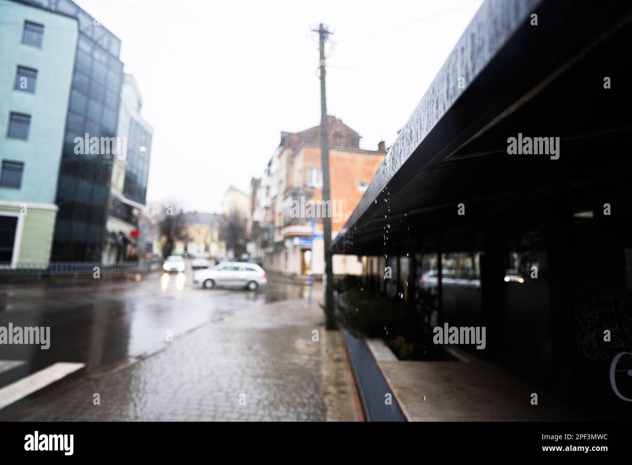 Rainwater flows down from the gutter in rain city street Stock Photo ...