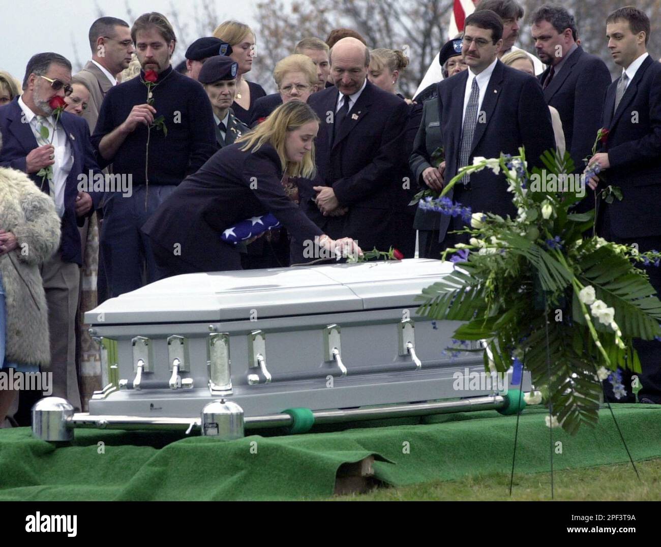 Jess Baillie, center, the fiancee of Sgt. Nick Tomko, places a flower ...