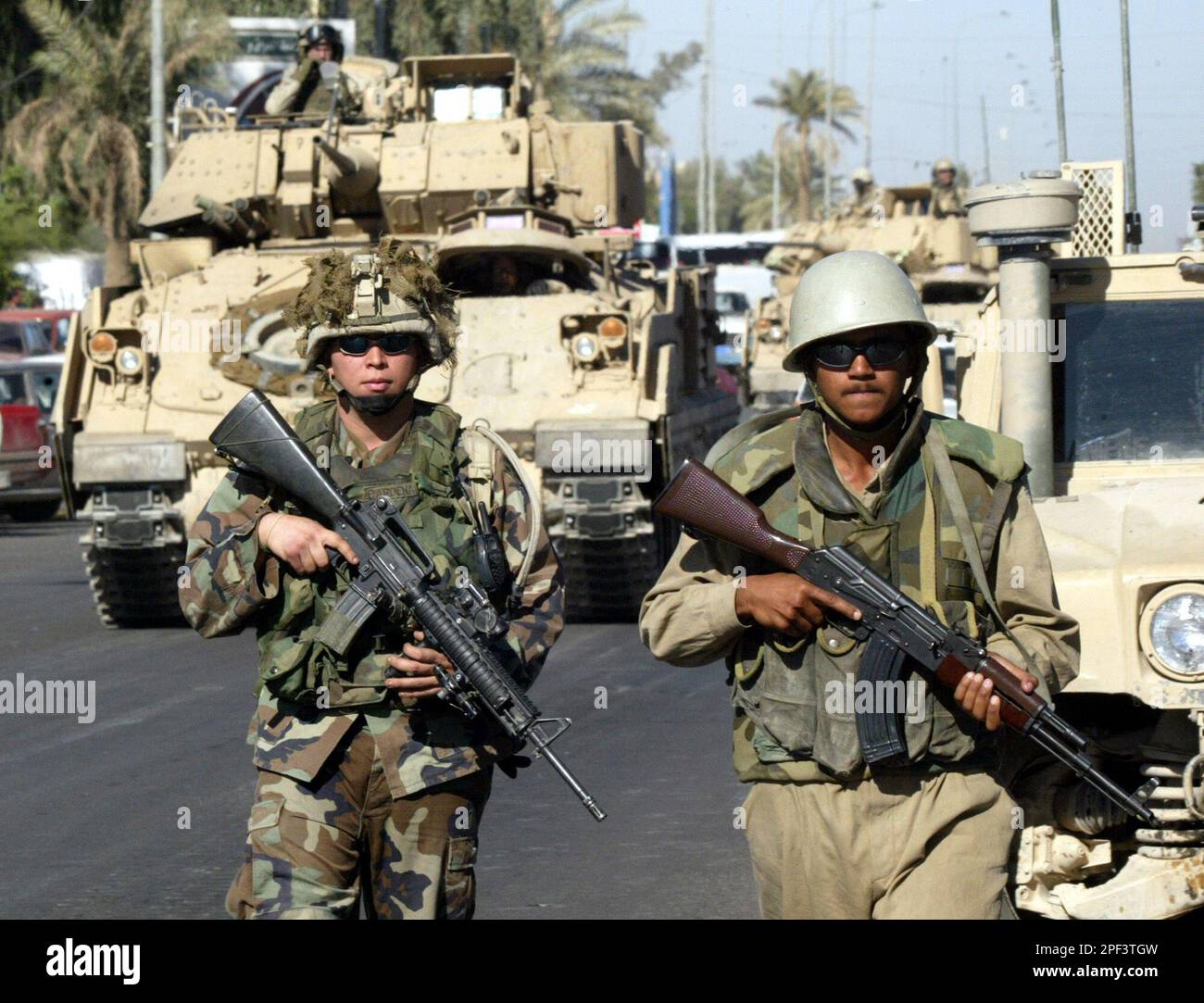 A soldier of U.S. Army's 4th Infantry Division, left and a member of ...
