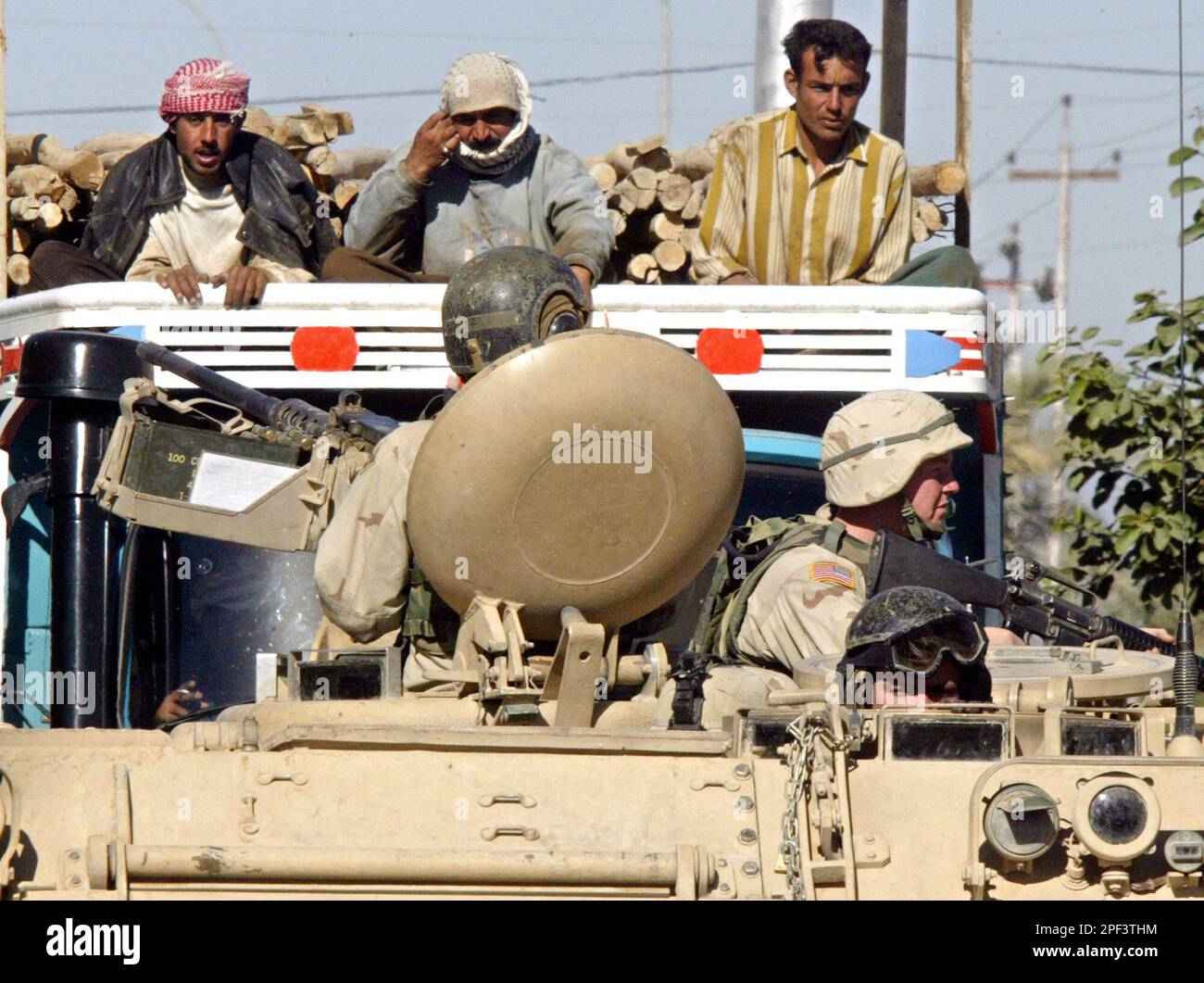 Iraqi's look on as soldiers of U.S. Army's 4th Infantry Division (Task ...