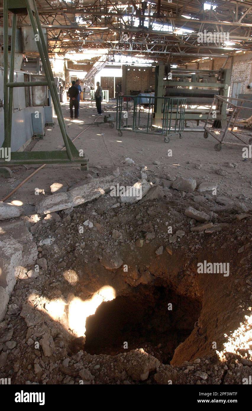 People inspect damage to a warehouse in Baghdad, Thursday, Nov. 13 ...