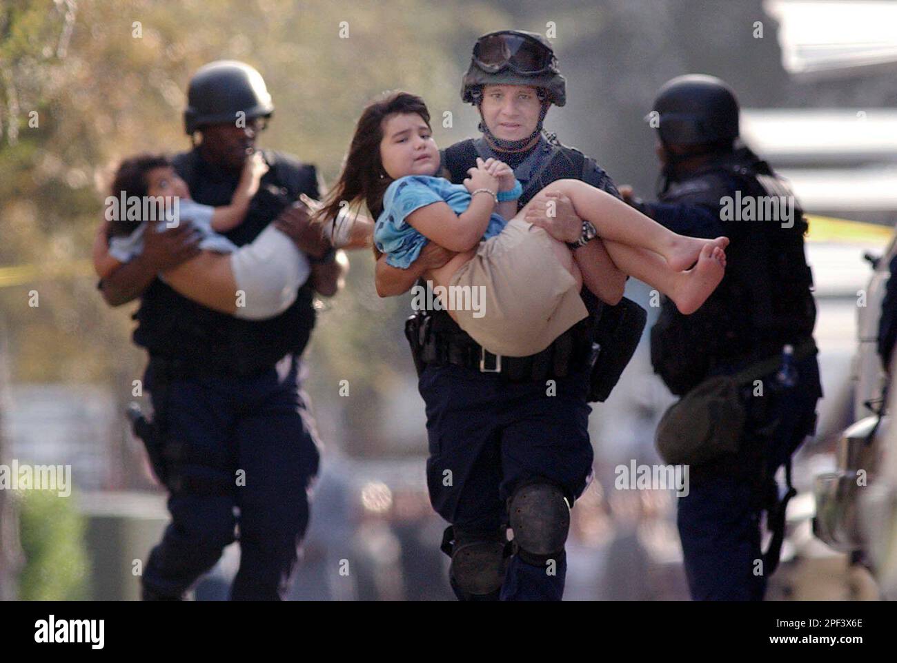 Dallas police SWAT members carry from an apartment building two girls ...
