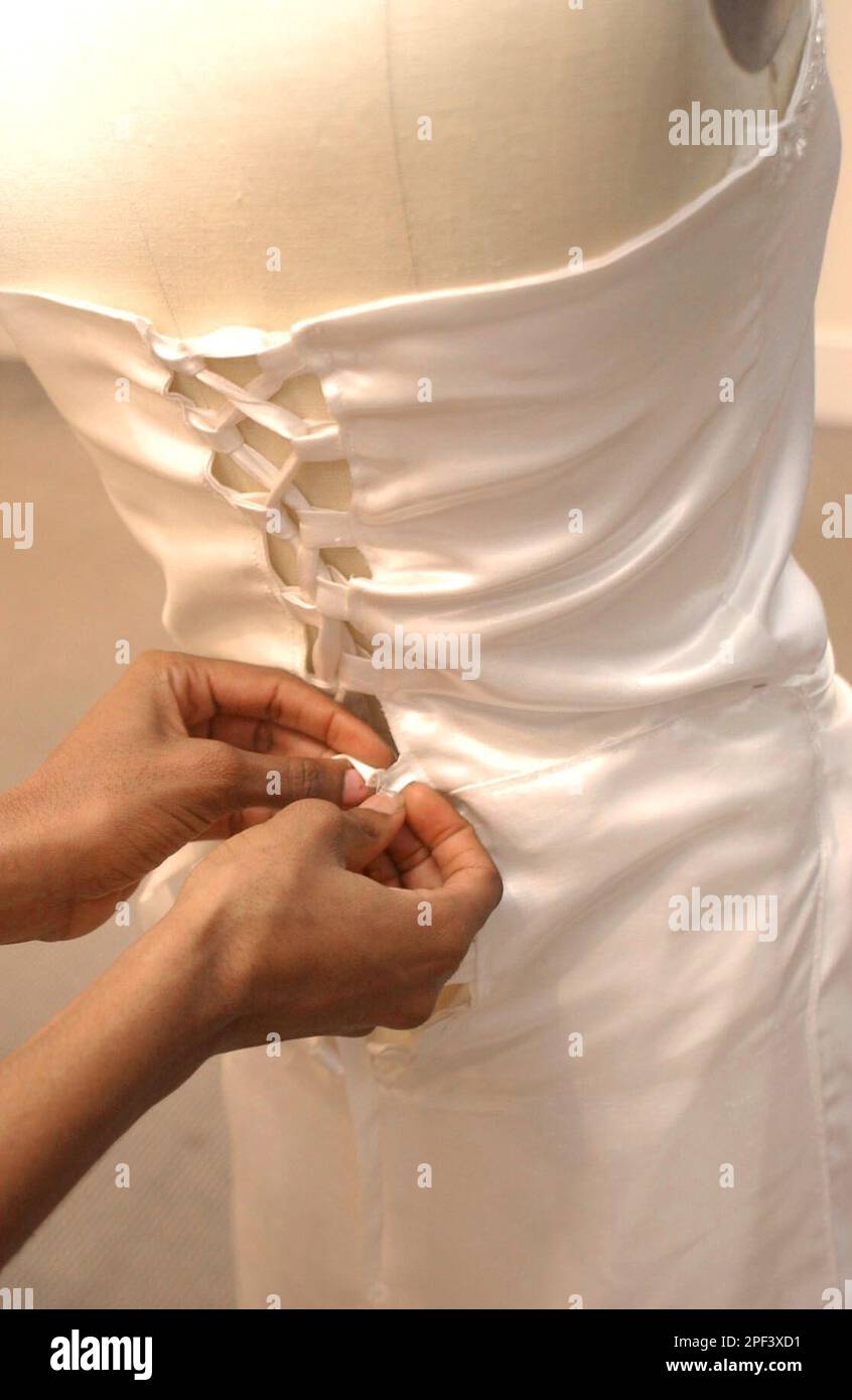 Ayisha Bennett pulls material through and laces the back of a custom ...