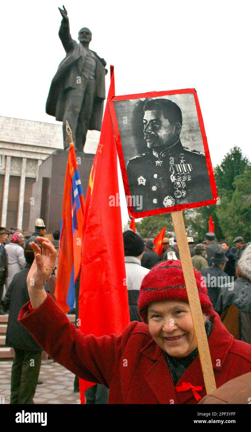 A supporter holds a portrait of Soviet dictator Josef Stalin, with a ...