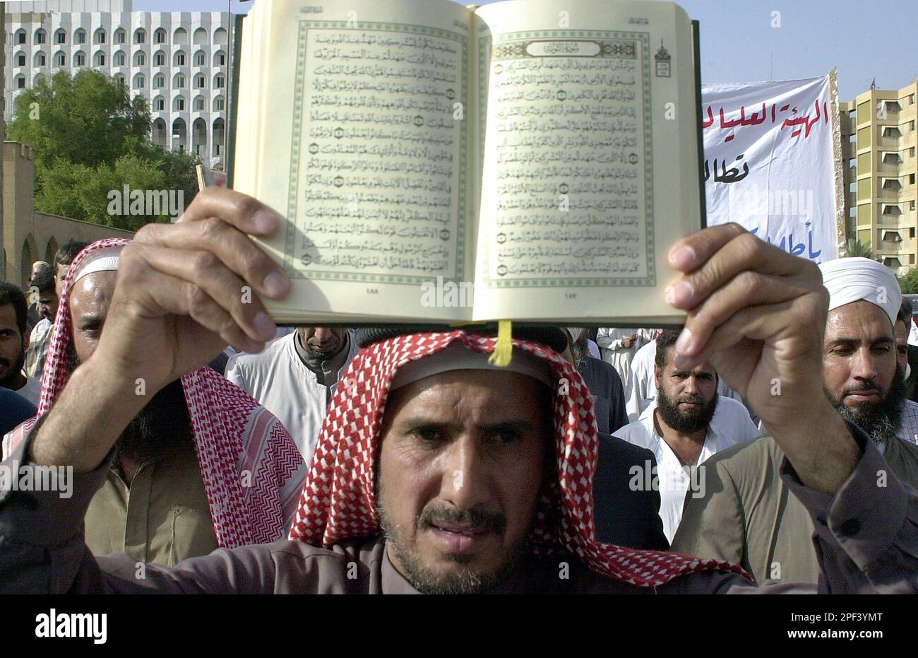An Iraqi man holds up the Quran, Islam's holy book during a rally in ...