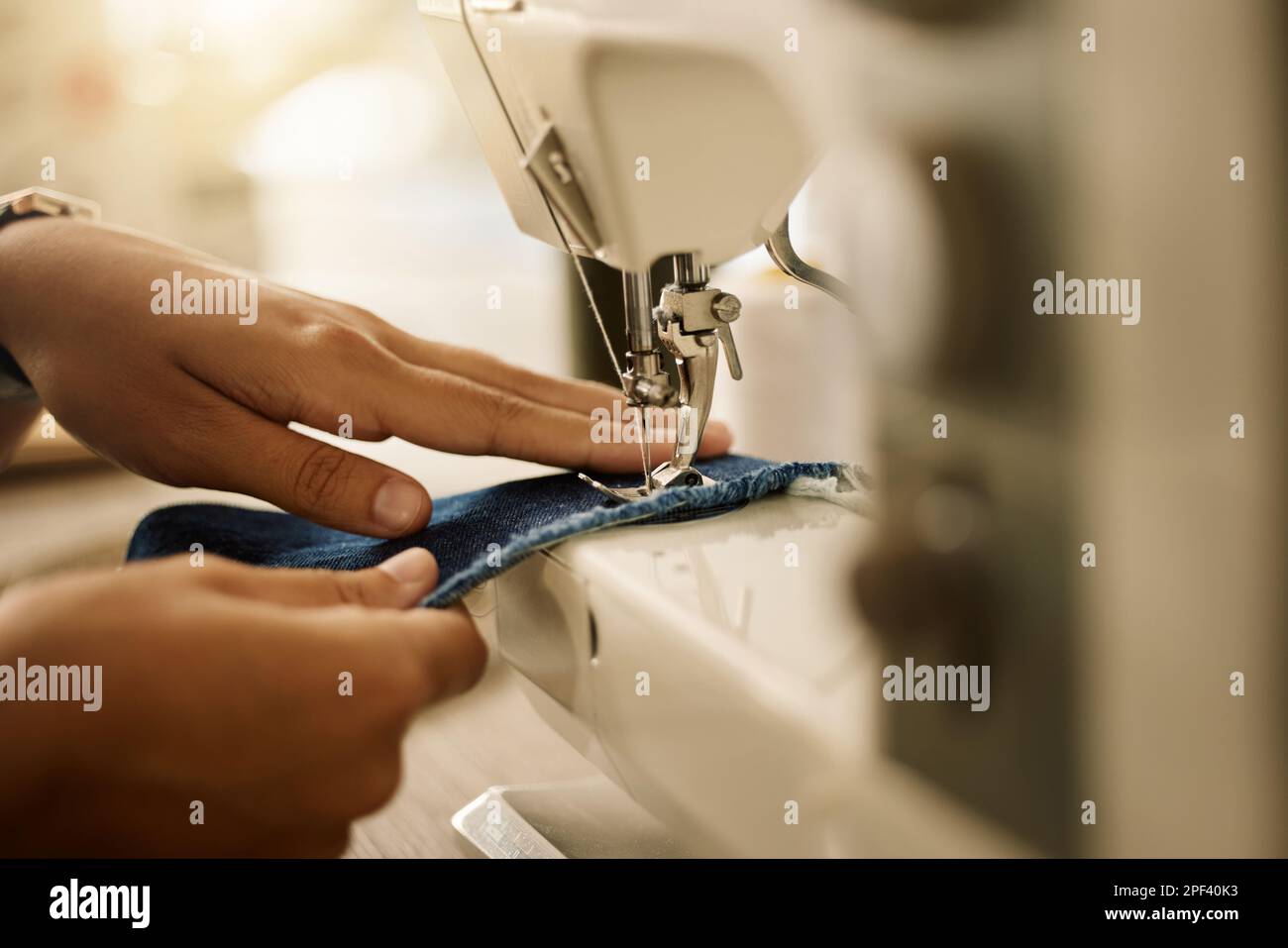 Zoom into hands of a seamstress sewing a piece of fabric. Fashion ...