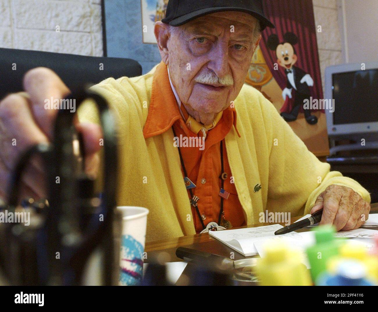 John Hench, 95, reaches for a pencil while working in his office Oct. 2 ...