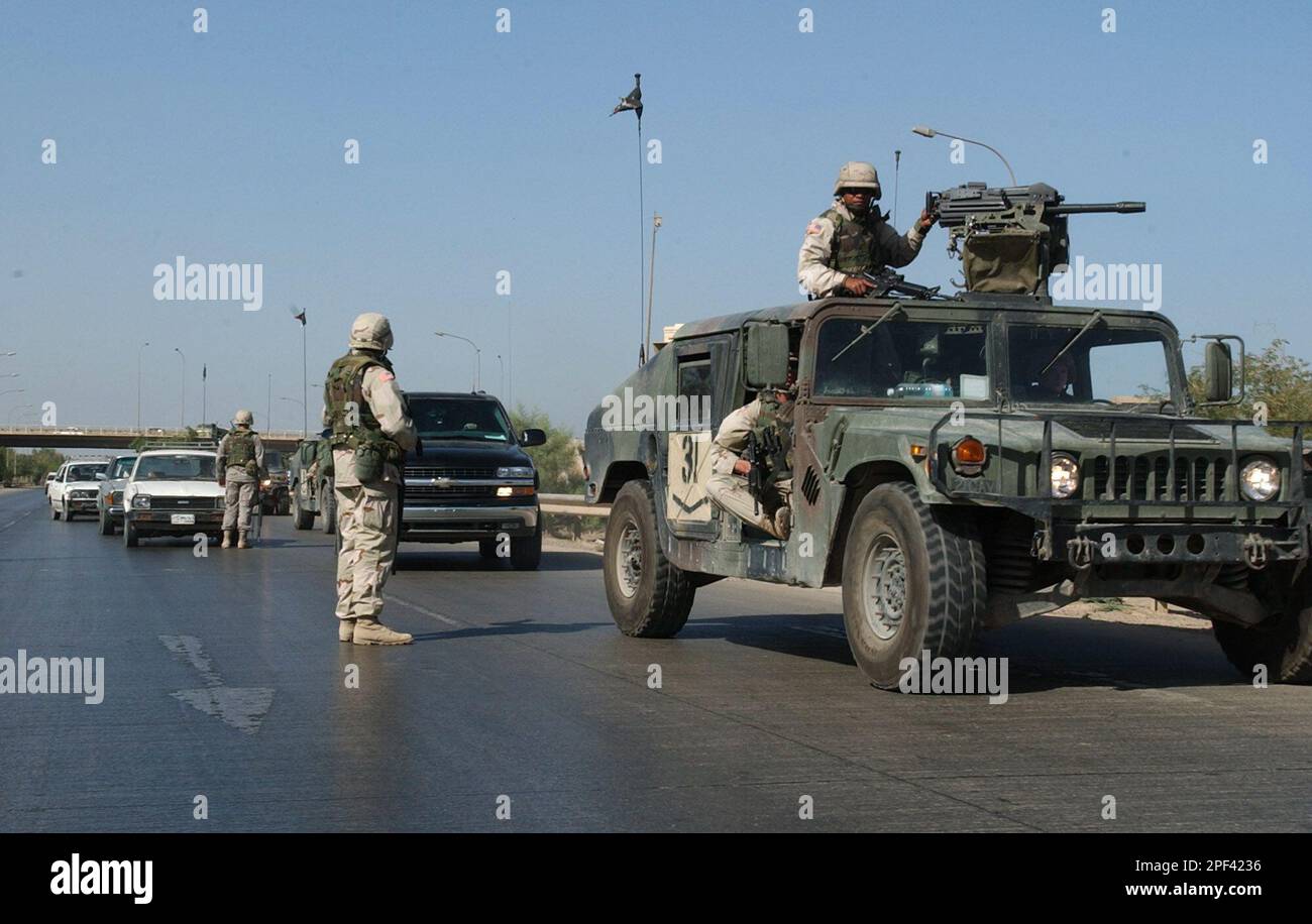 A US military vehicle drives past a checkpoint patrolled by US Army ...