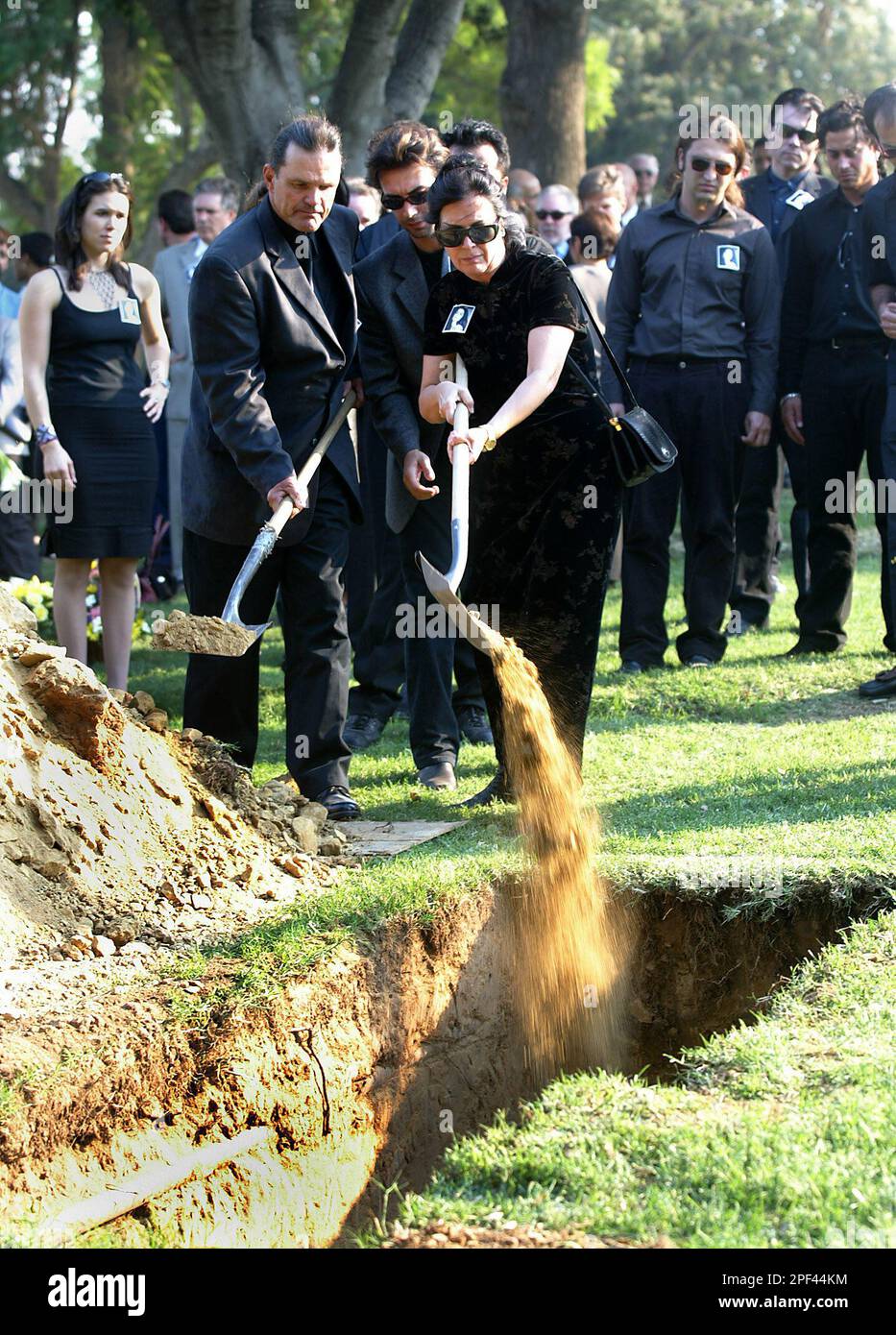 Zerrin Arbas, right, puts dirt on the coffin at the funeral of her ...