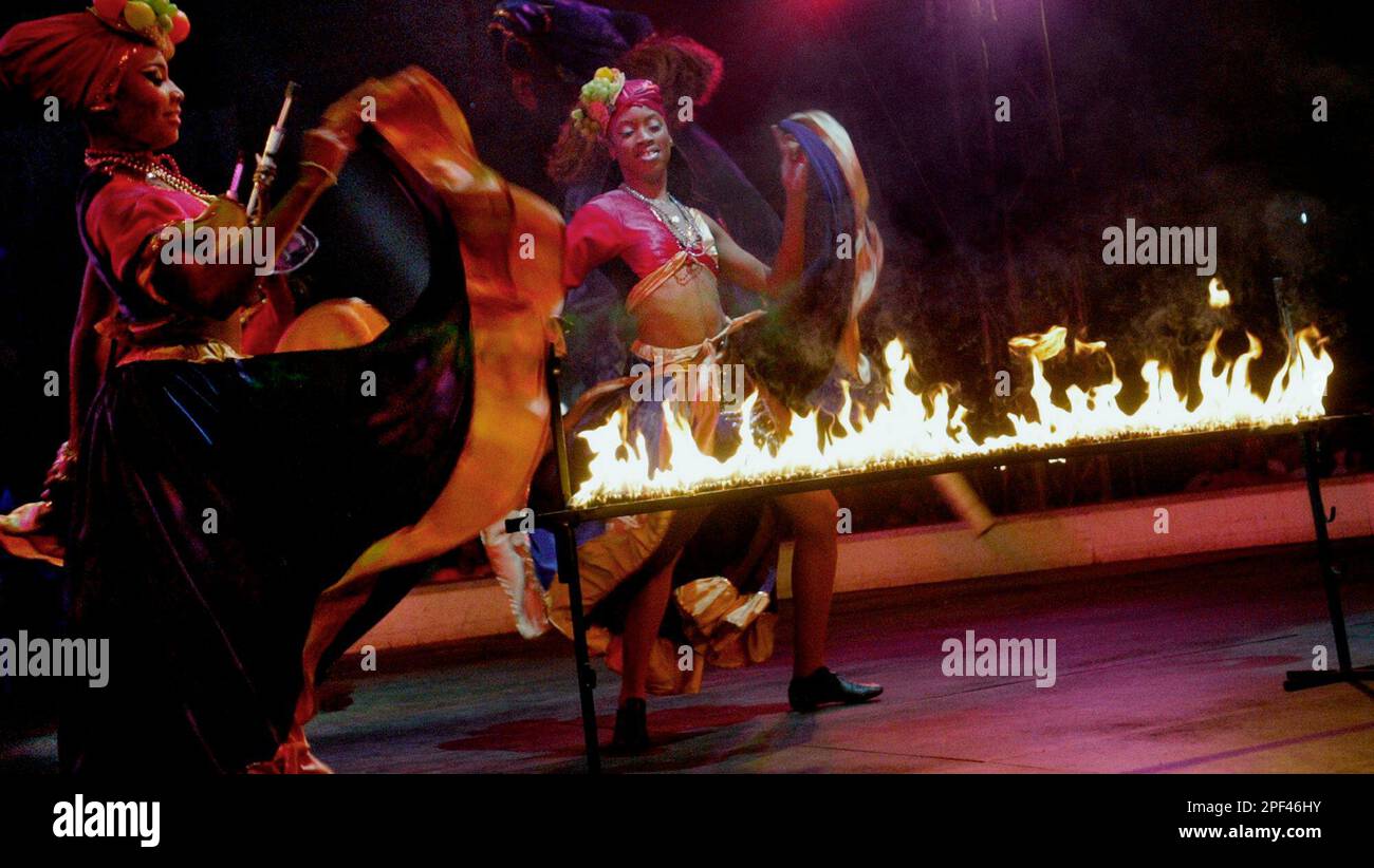 Nydia Byron, center, the "limbo queen," prepares to limbo under a bar ...