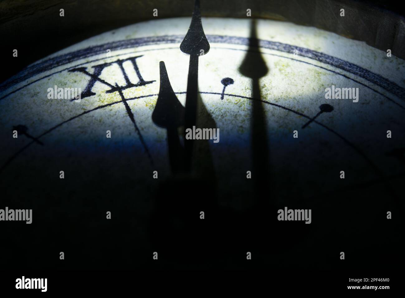 concept of time with the face of an old wall clock in directional light ...