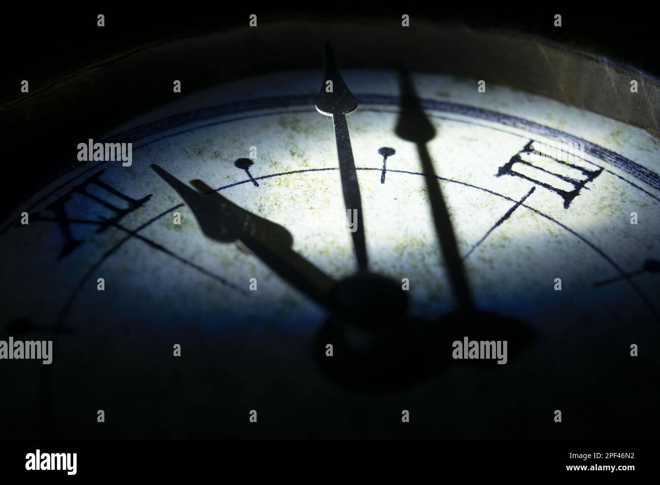 concept of time with the face of an old wall clock in directional light ...