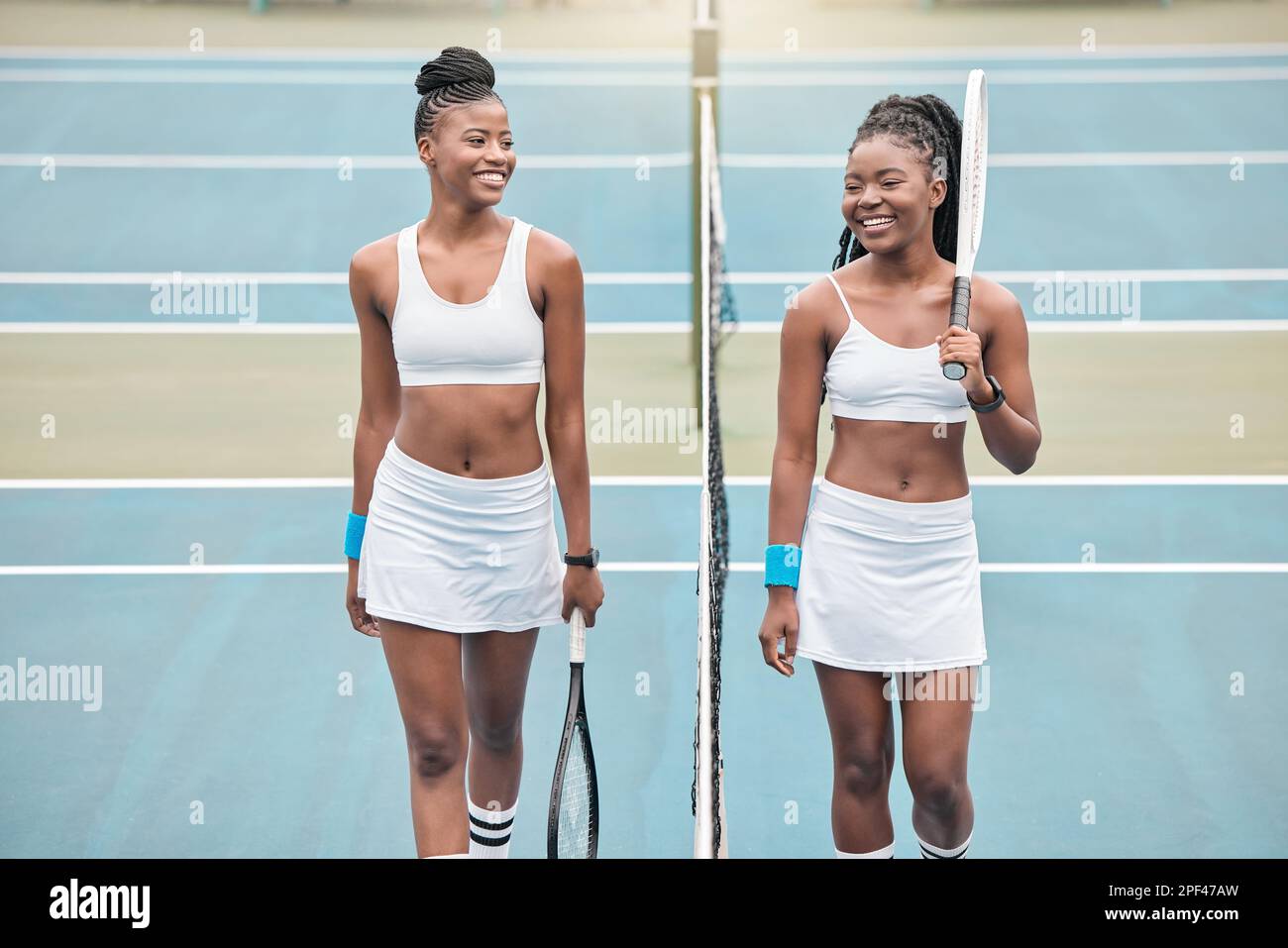 Smiling tennis players holding their rackets on the club court. Two ...
