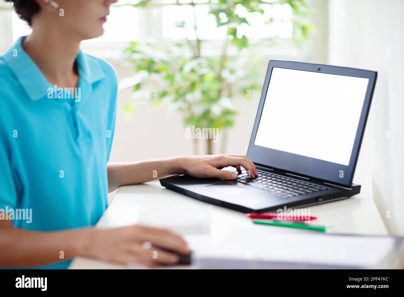 School child doing homework. Empty laptop screen. Copy space on ...
